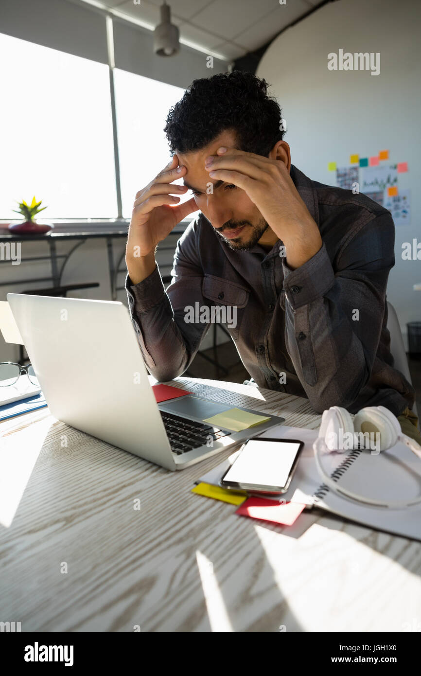 Frustrated young businessman siting at desk in office Stock Photo - Alamy