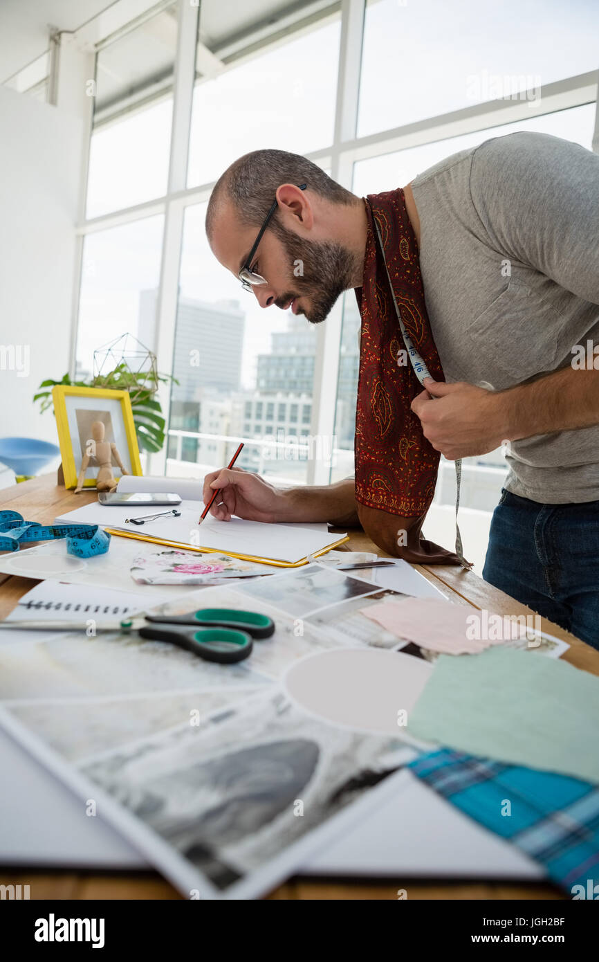 Male designer drawing sketch while standing at table in studio Stock ...