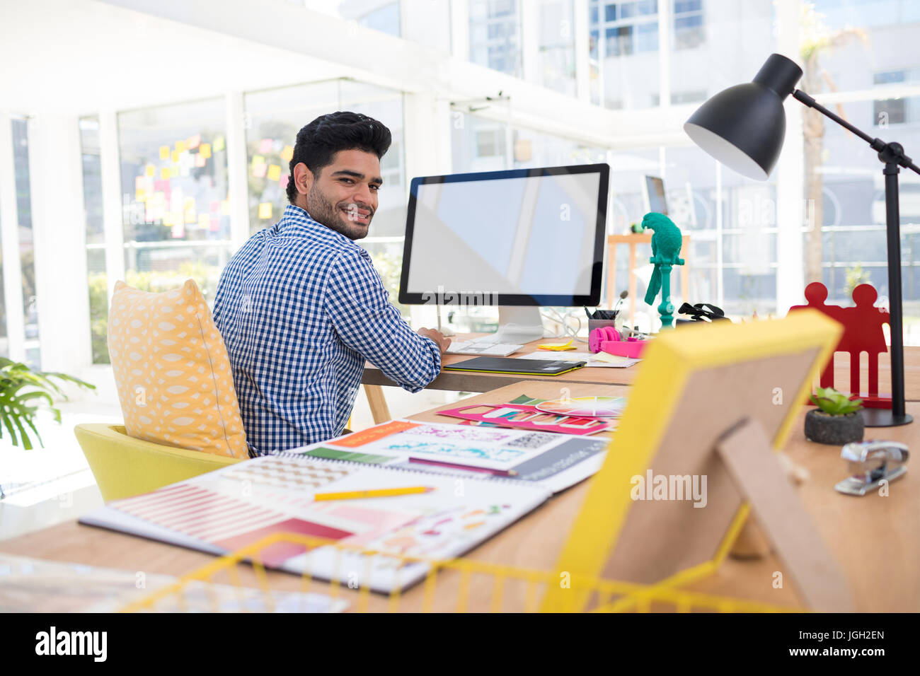 Graphic designer working on computer at desk in the office Stock Photo ...