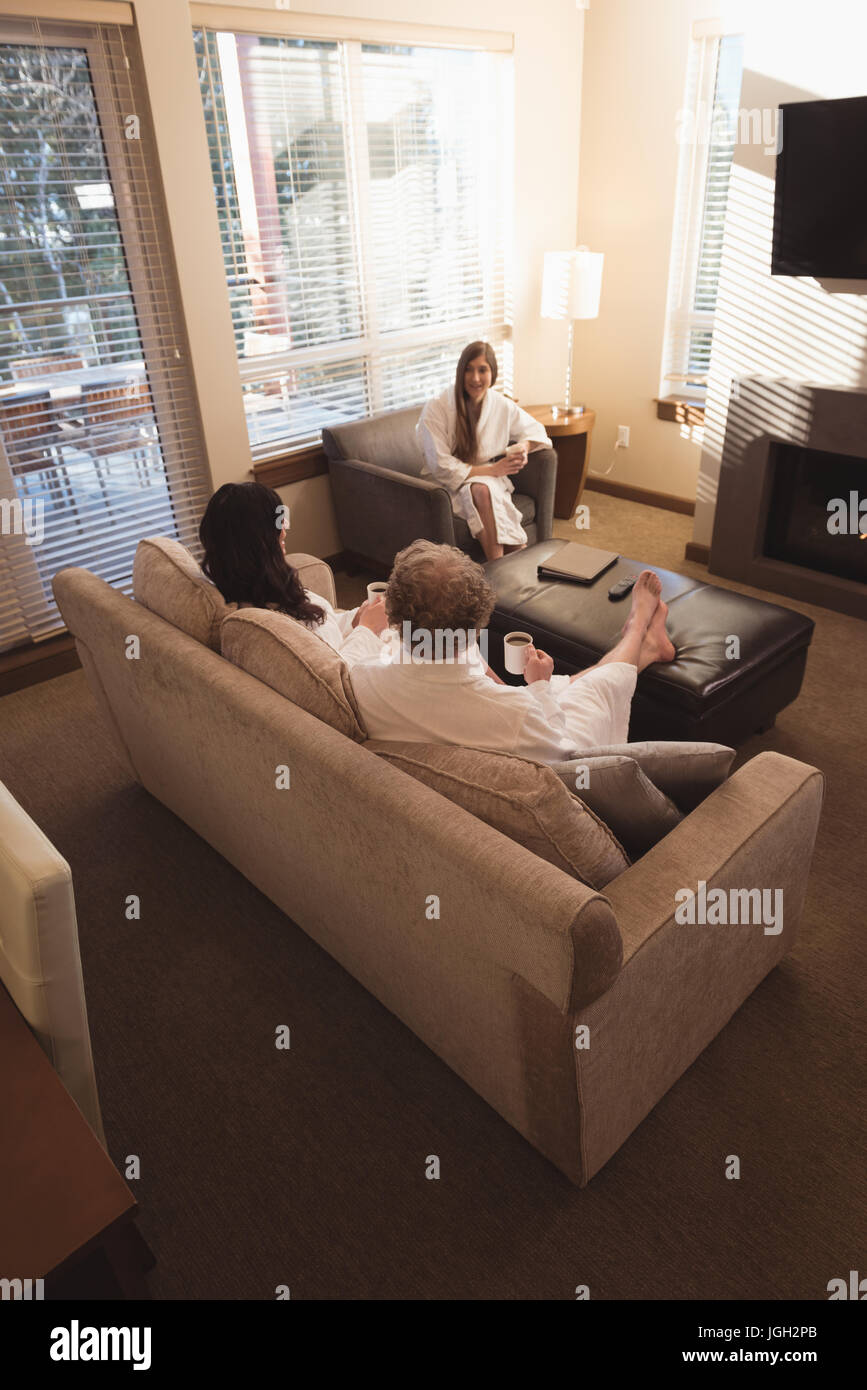 Friends relaxing while having coffee in the living room at home Stock ...