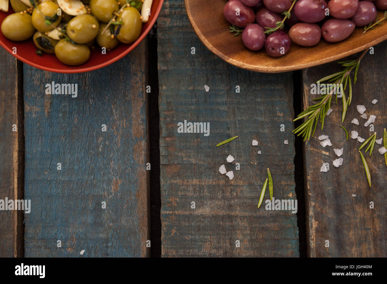 Overhead view of olives in plates on wooden table Stock Photo - Alamy