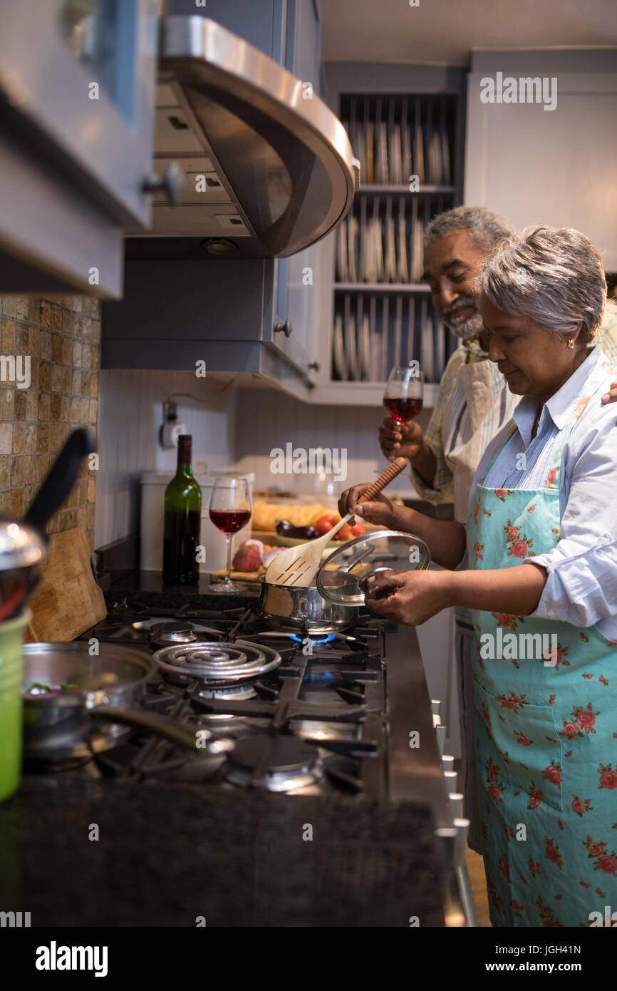 Man and woman preparing food while standing in kitchen at home Stock ...