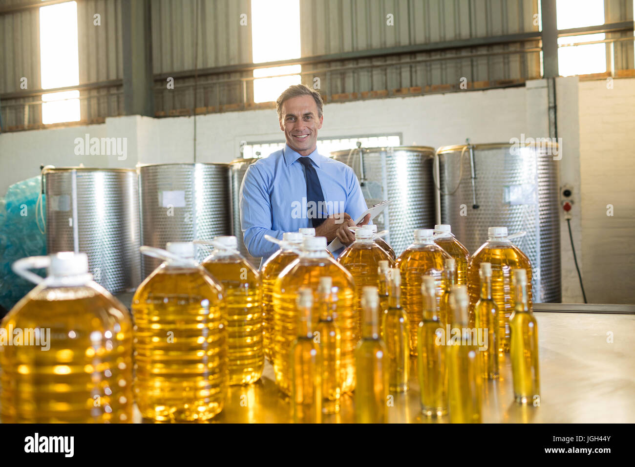 Portrait of manager maintaining record on clipboard in factory Stock ...