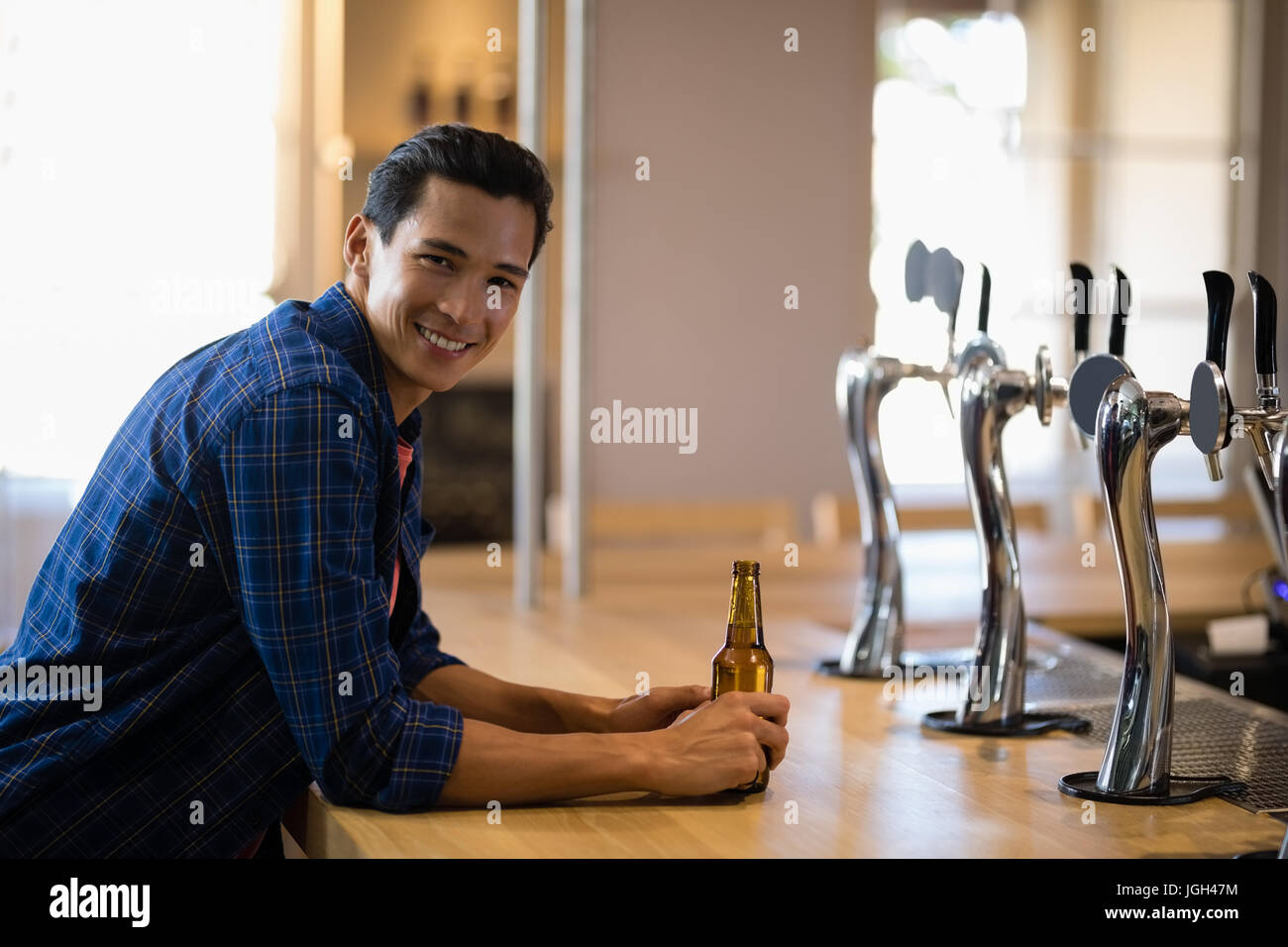 Portrait of man having beer at counter in bar Stock Photo - Alamy