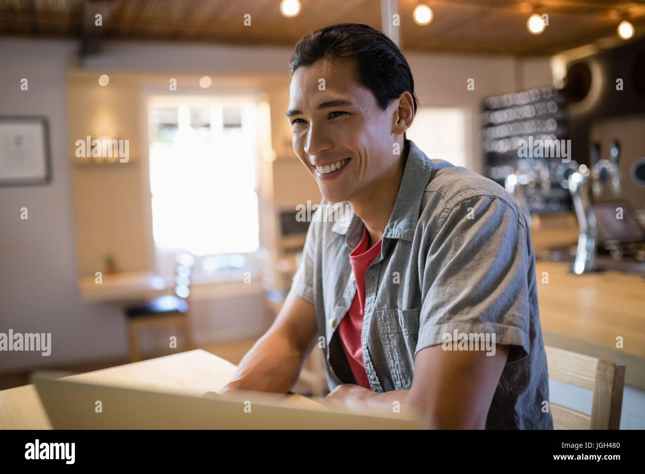Smiling man sitting in bar Stock Photo - Alamy