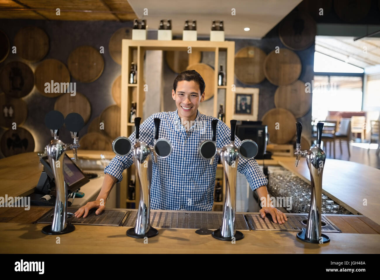 Portrait of bar tender standing at counter in restaurant Stock Photo ...