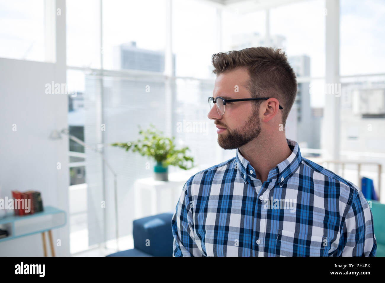 Young male executive standing in the office Stock Photo - Alamy
