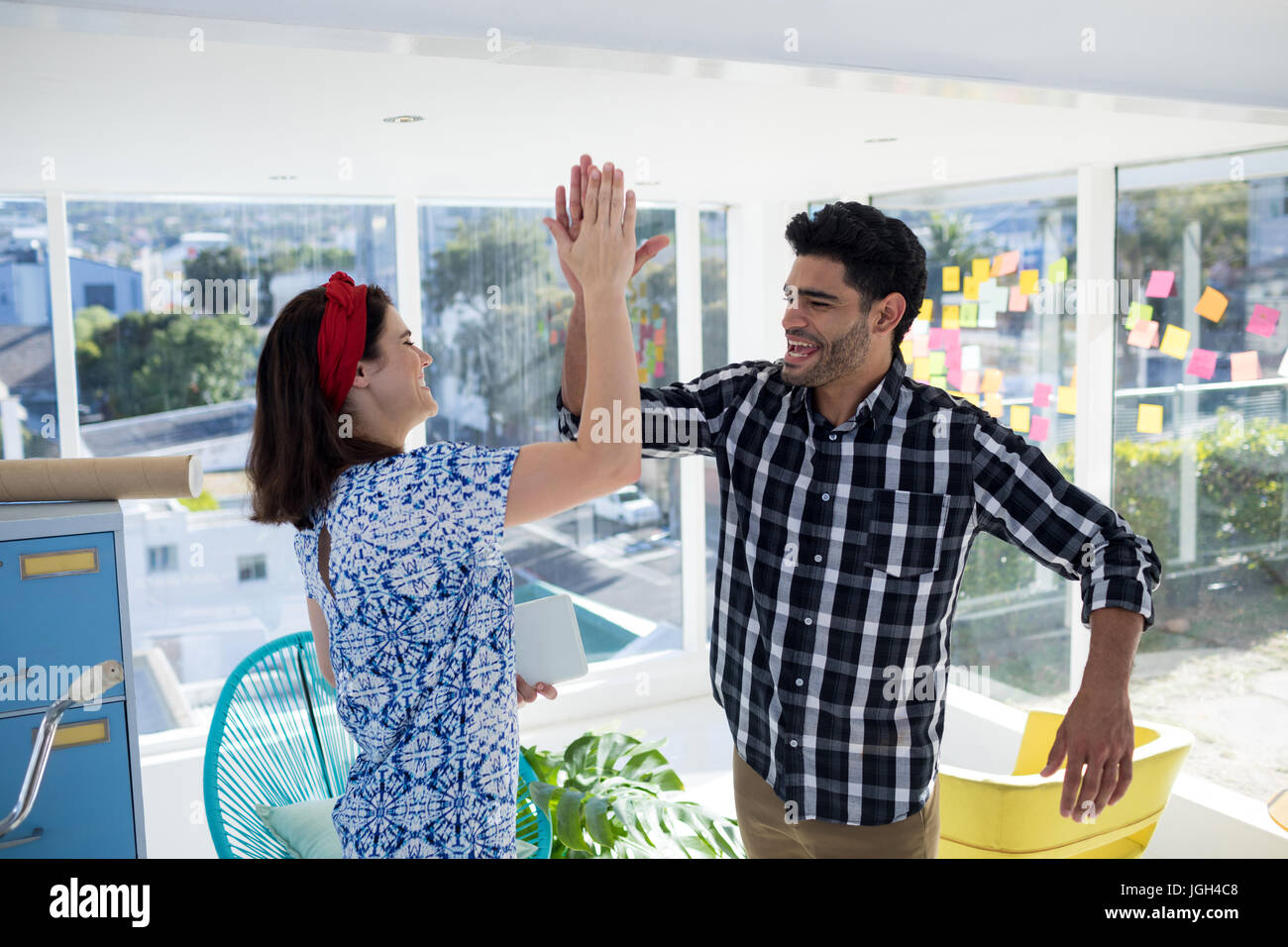 Happy couple giving high five to each other in the office Stock Photo ...
