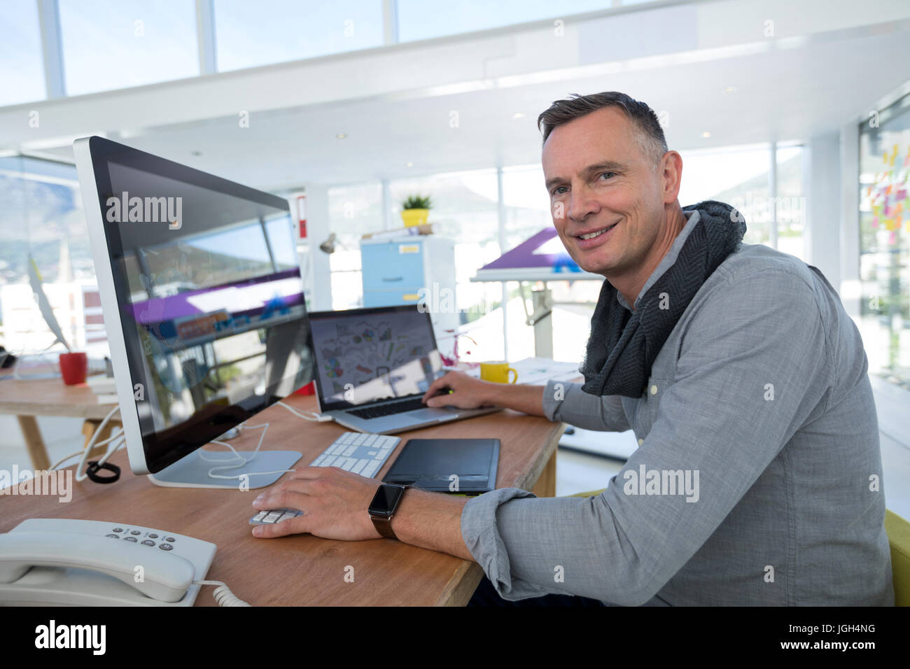 Portrait of male executive working at desk in the office Stock Photo ...