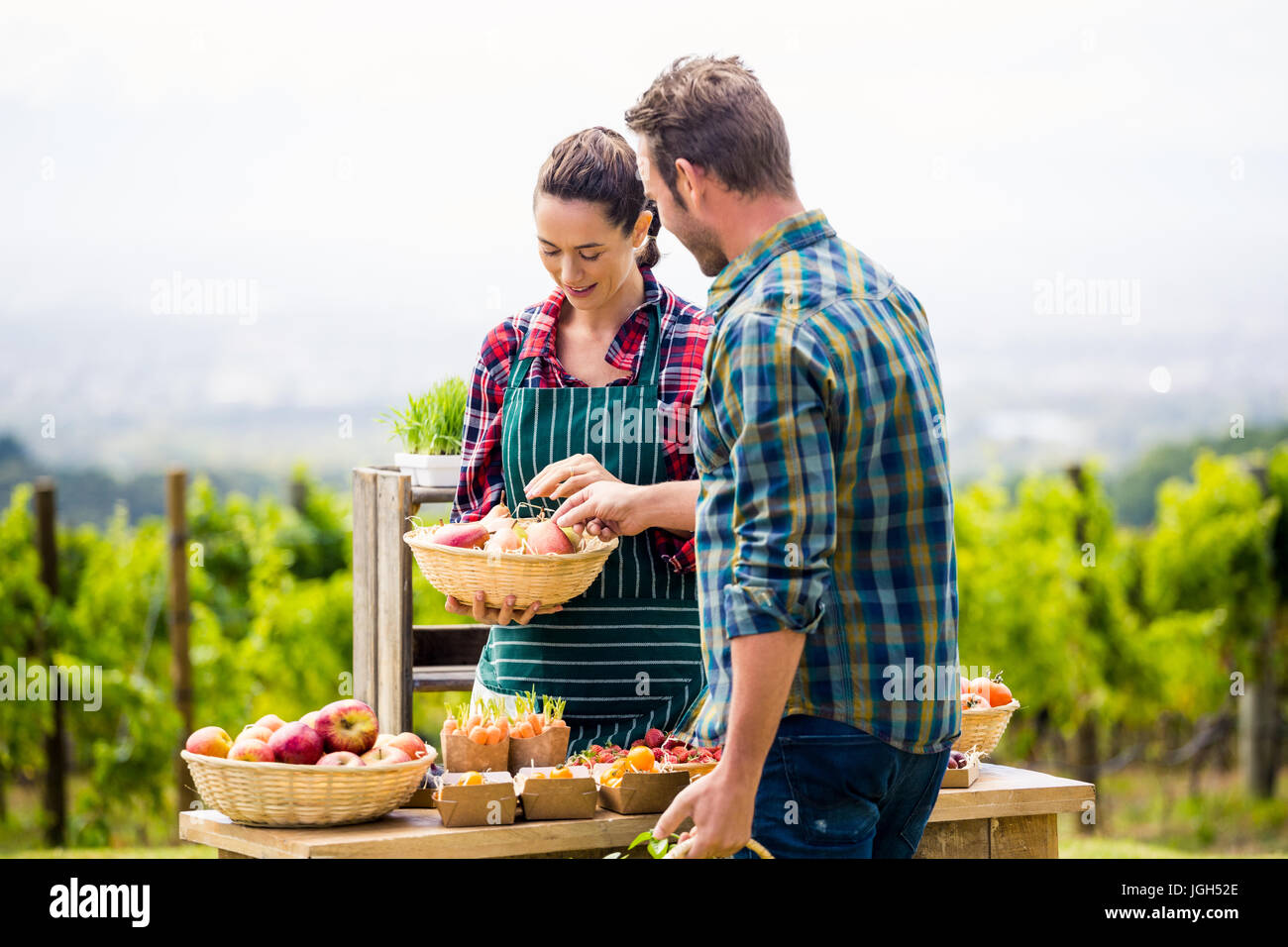 Young woman selling organic vegetables to man standing at farm Stock ...