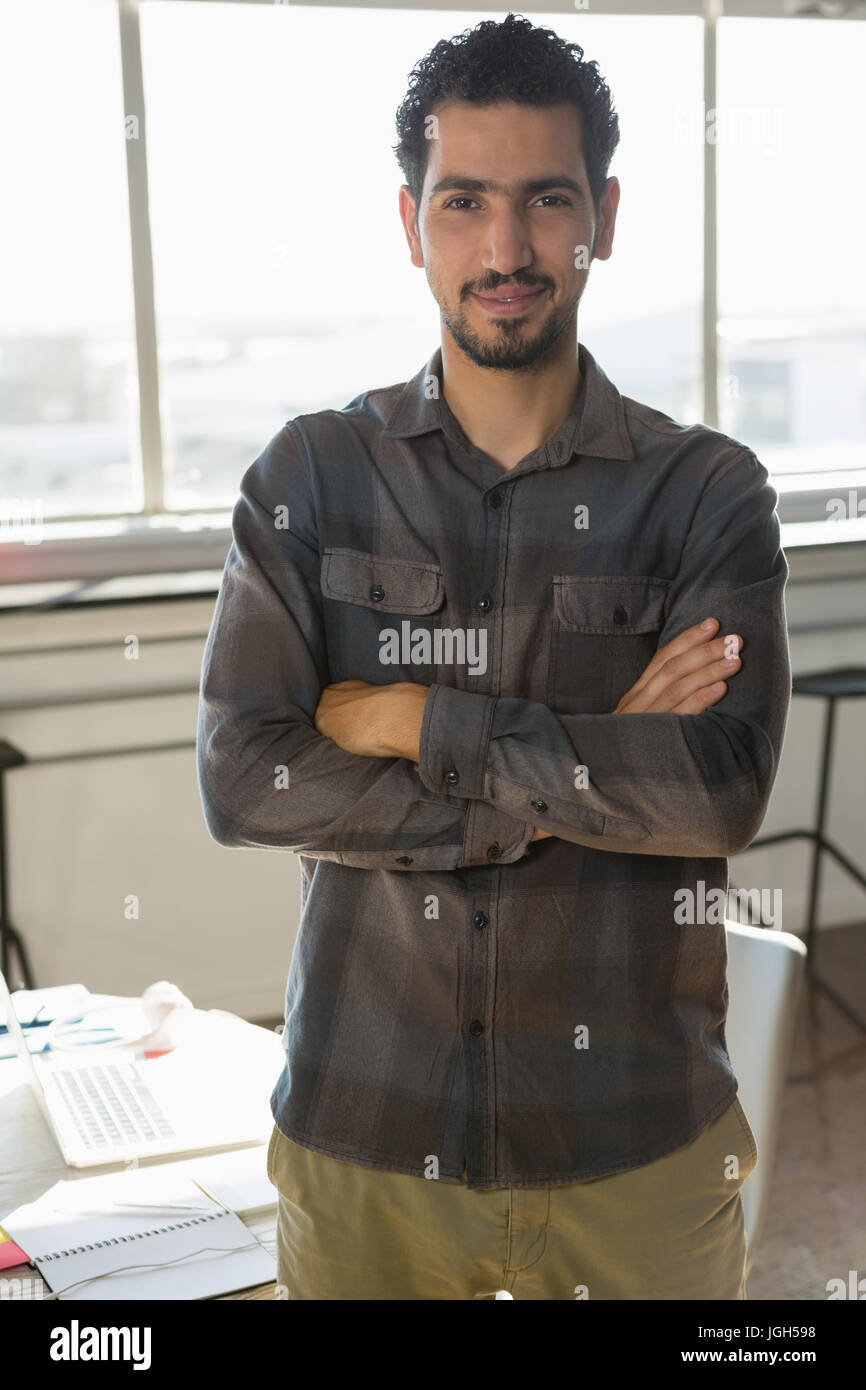 Portrait of young man standing against window at office Stock Photo - Alamy