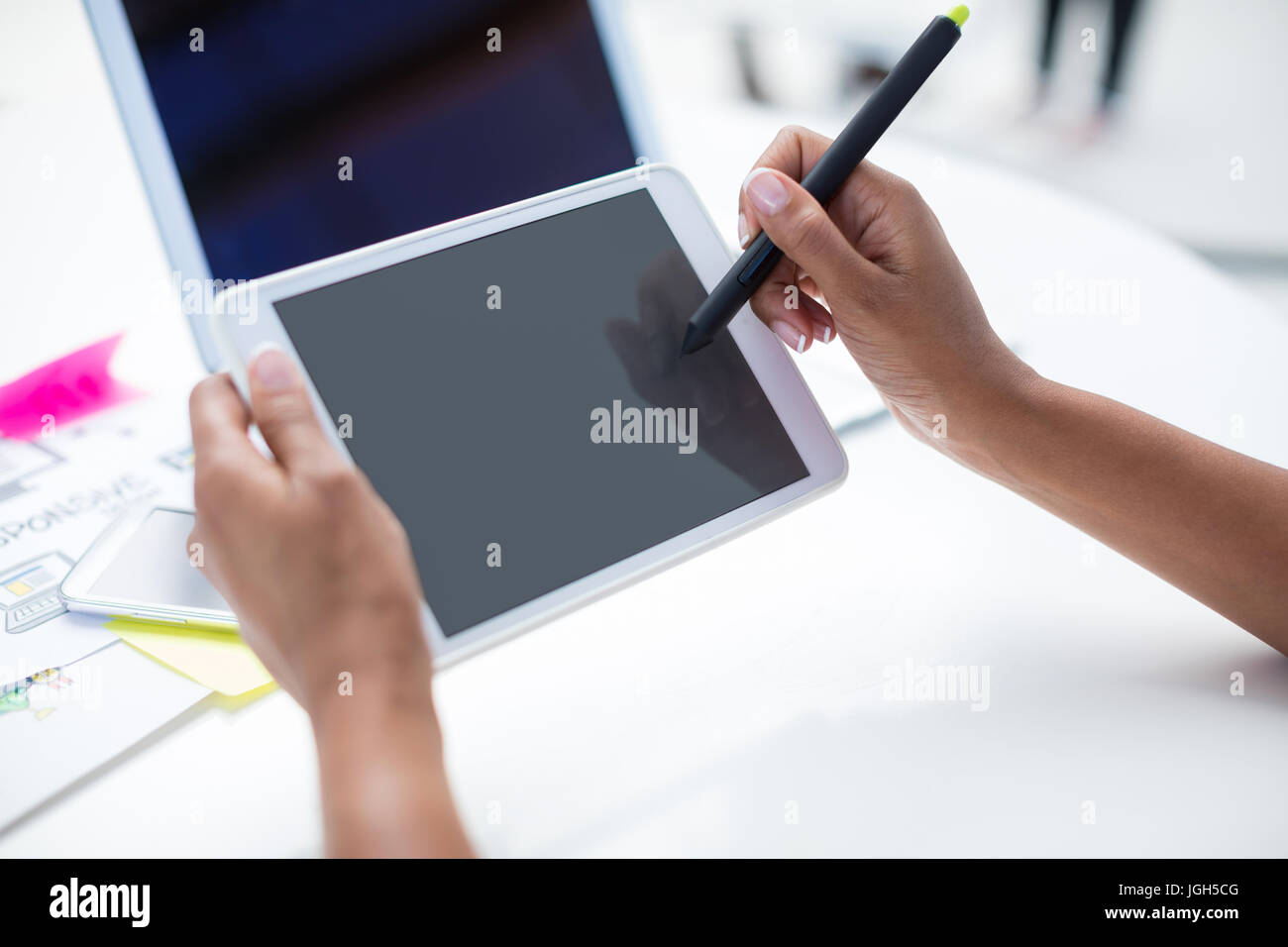 Hands of female graphic designer using graphic tablet at desk in the ...