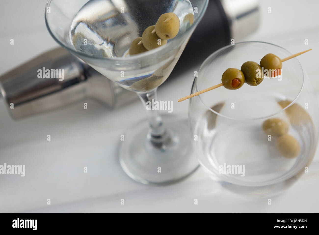 High angle view of vodka martini with cocktail shaker on wooden table ...