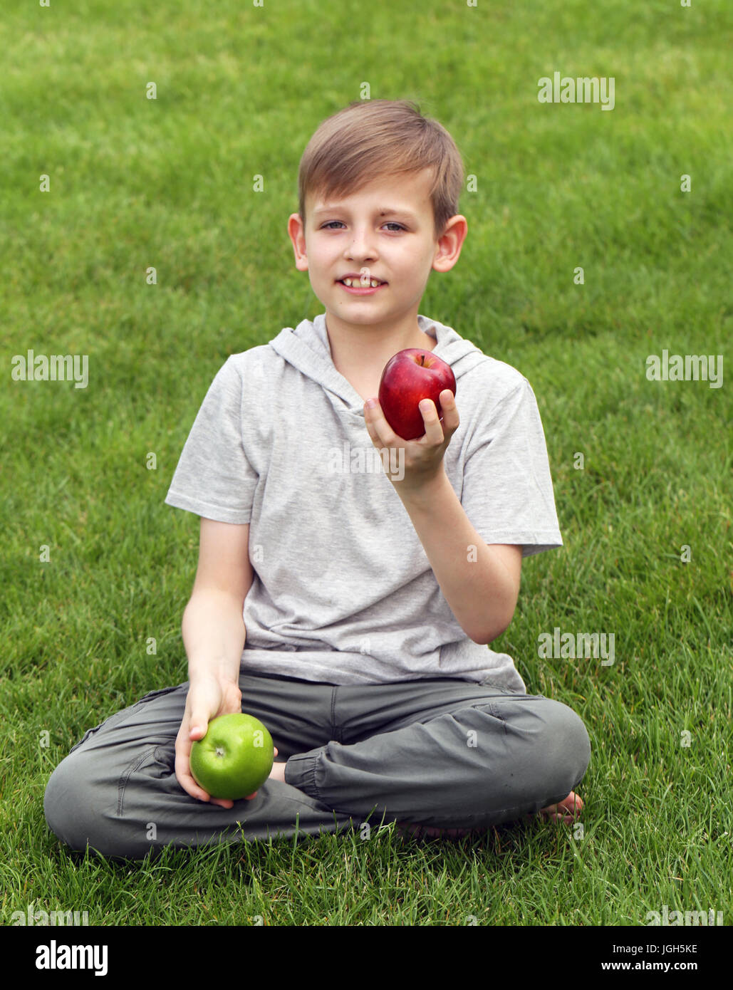 Cute young boy with apples on green grass - summer time, picnic Stock ...