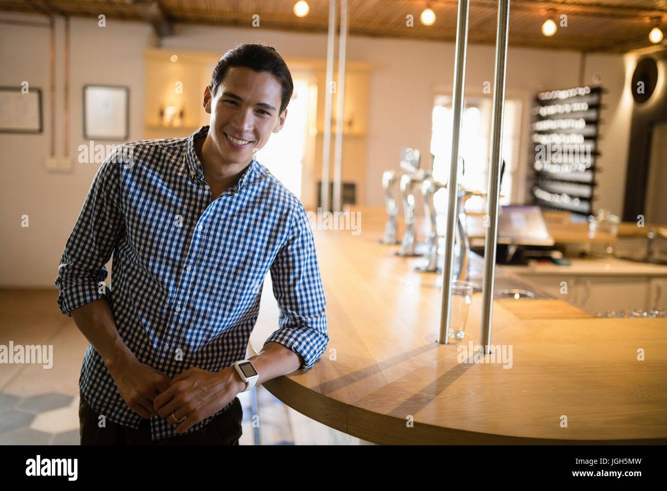 Portrait of smiling man standing at counter in restaurant Stock Photo ...