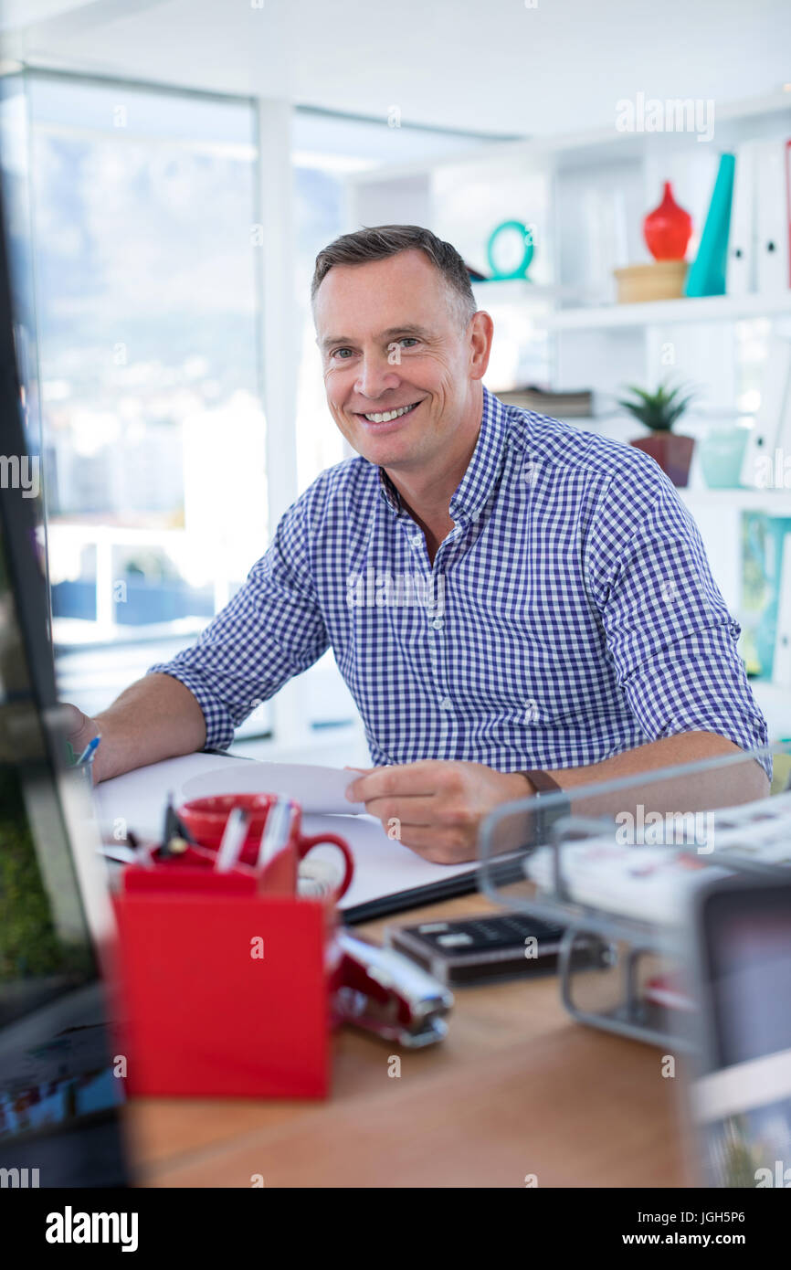 Portrait of male executive working at desk in the office Stock Photo ...