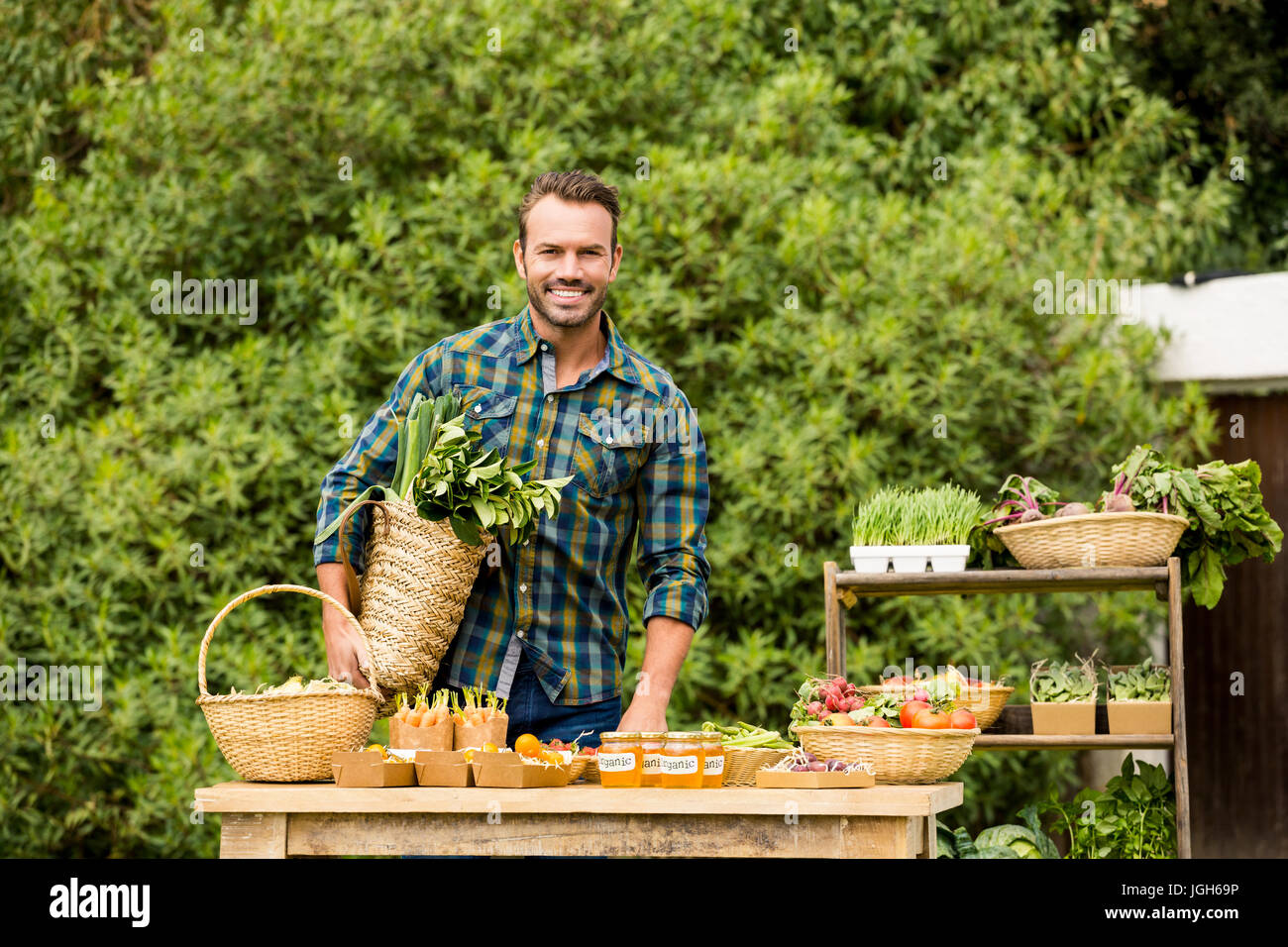Portrait of smiling man selling organic vegetables while standing ...