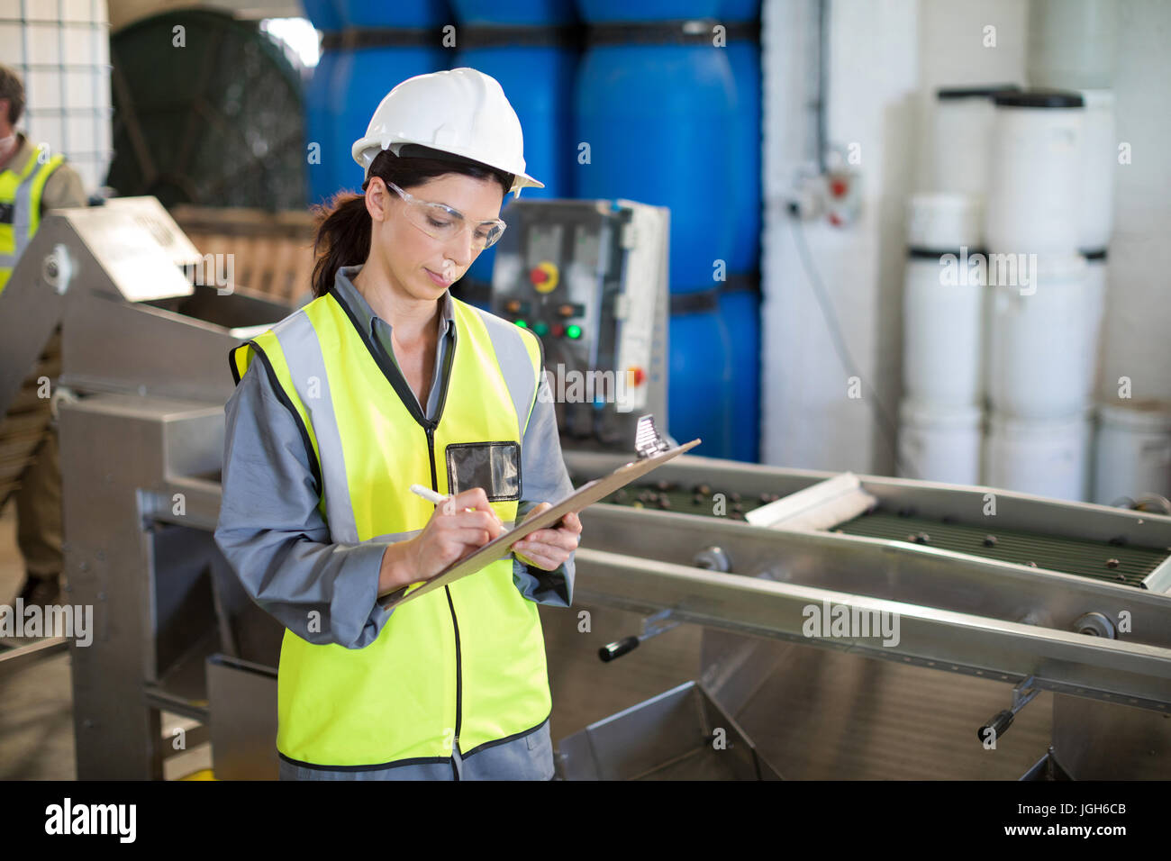 Female technician writing in clipboard at oil factory Stock Photo - Alamy
