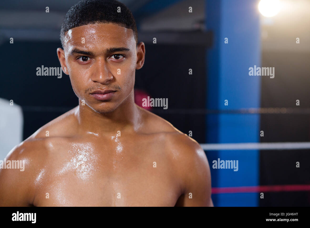 Portrait of confident young male boxer standing in boxing ring Stock ...