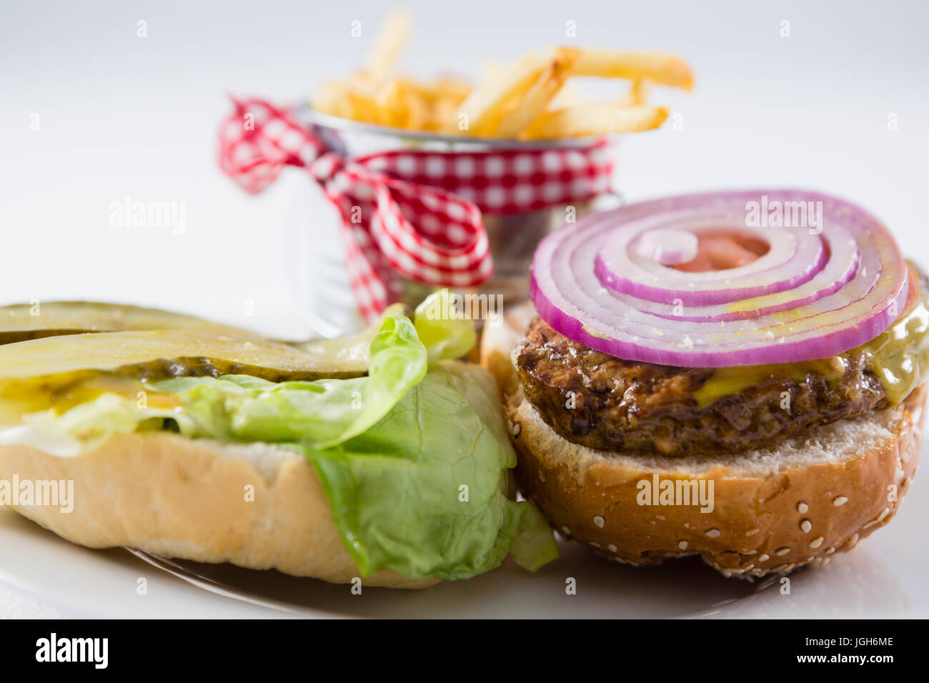 Close up of open burger by French fries in container on plate against ...
