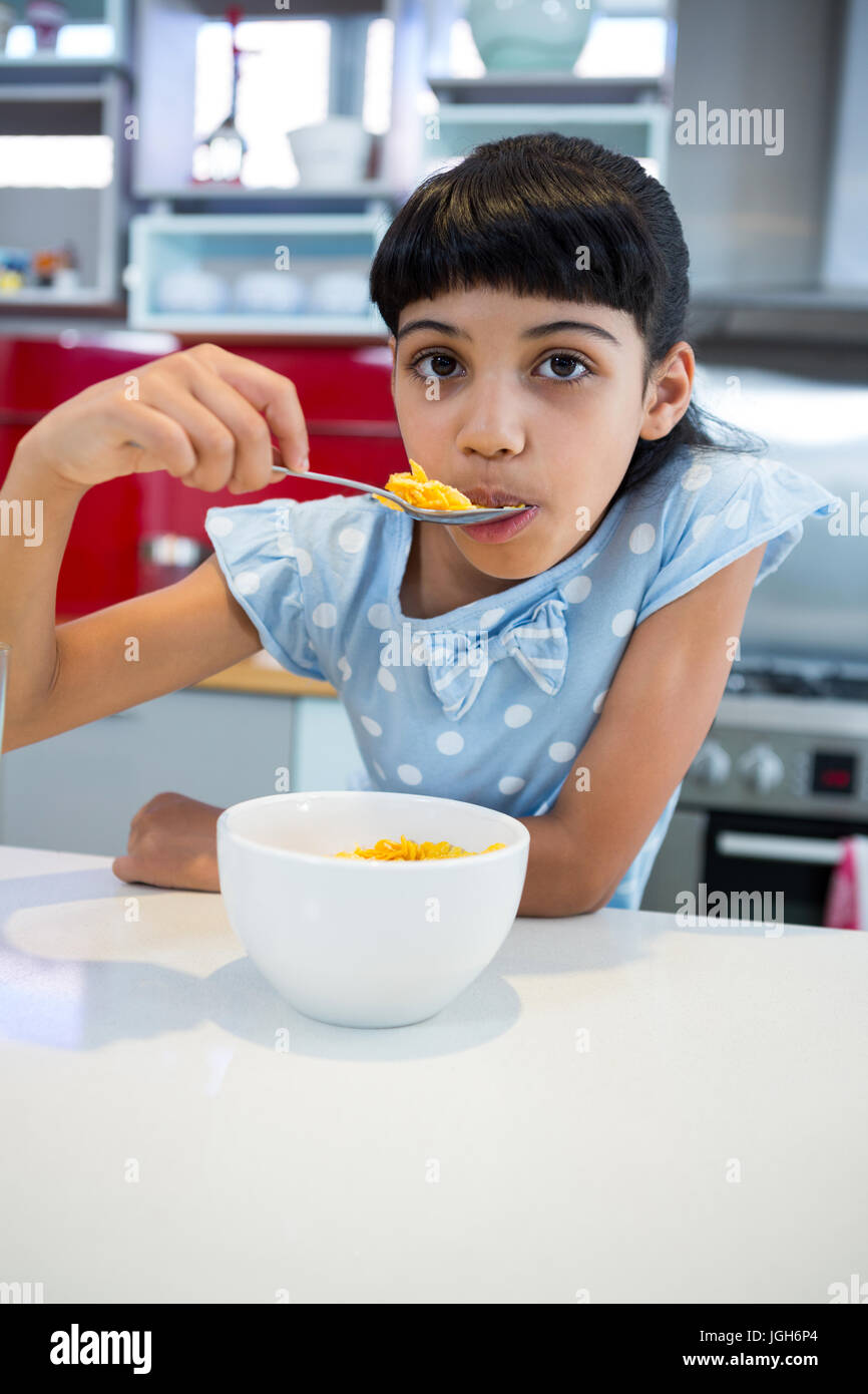 Portrait of girl eating breakfast in kitchen at home Stock Photo - Alamy