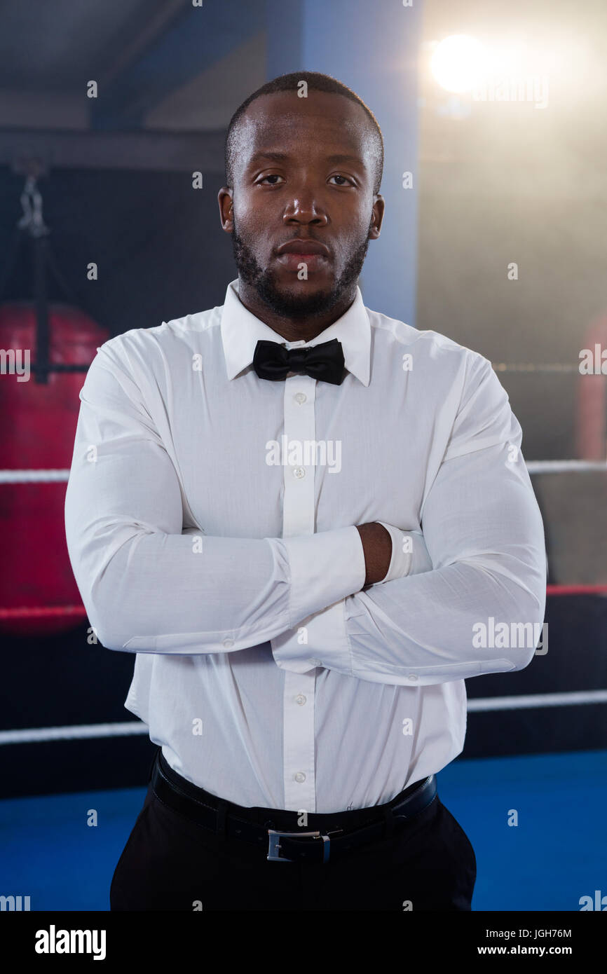 Portrait of young male referee standing with arms crossed in boxing ...