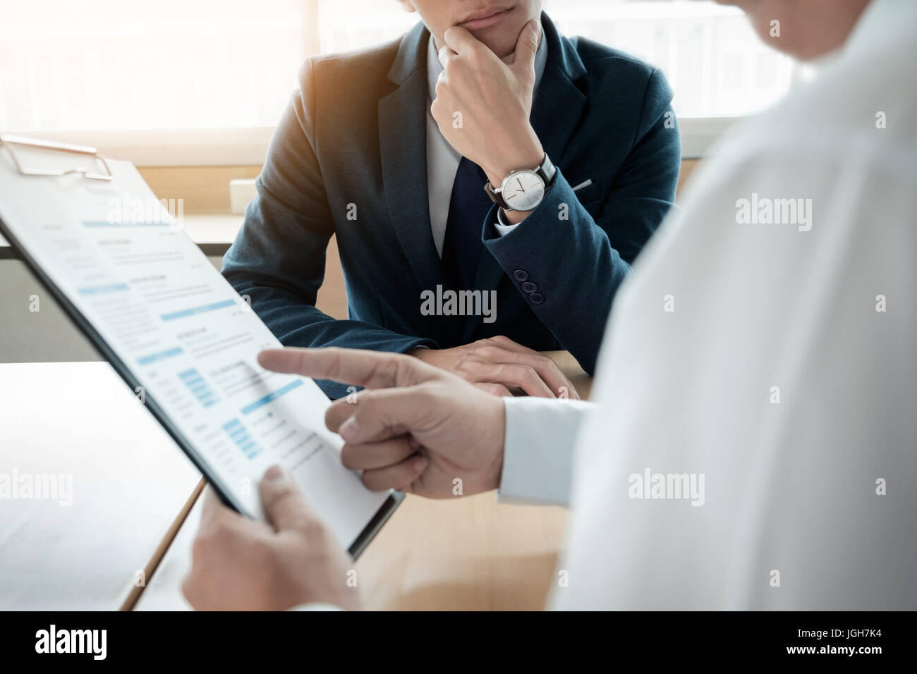 business man interviewer looking skeptical while listening to an asian ...