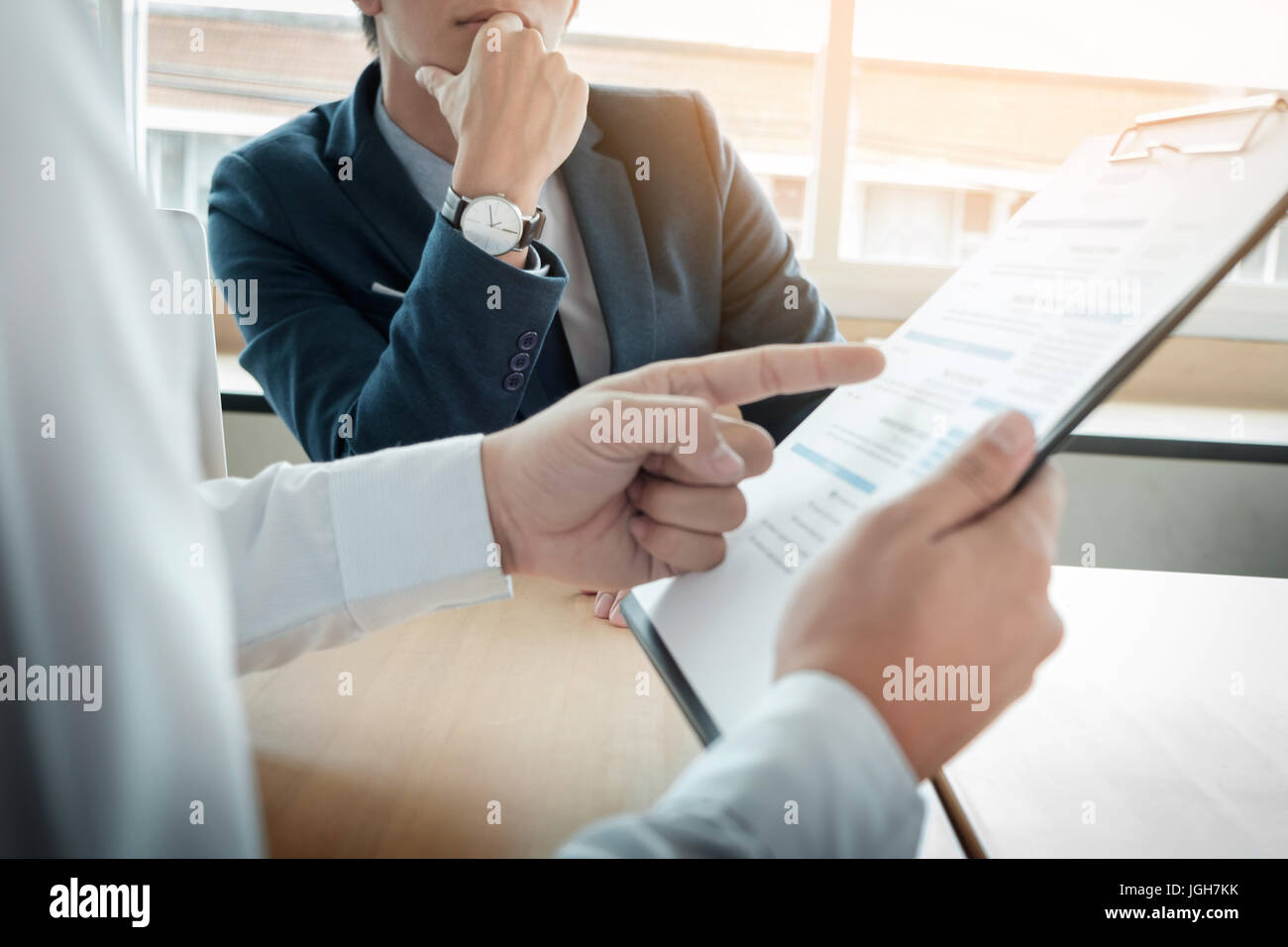 business man interviewer looking skeptical while listening to an asian ...