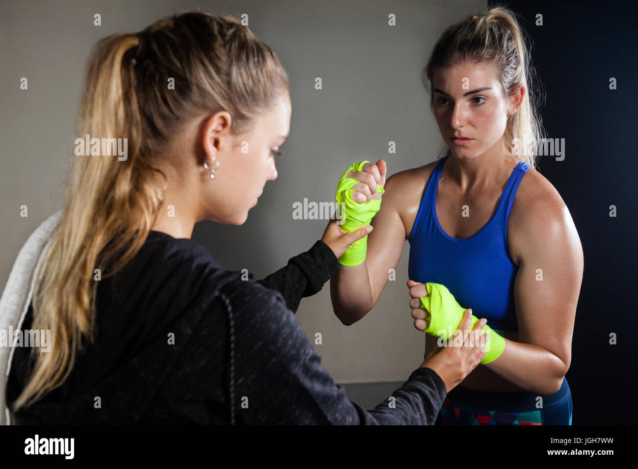 Trainer assisting woman in boxing at fitness studio Stock Photo - Alamy