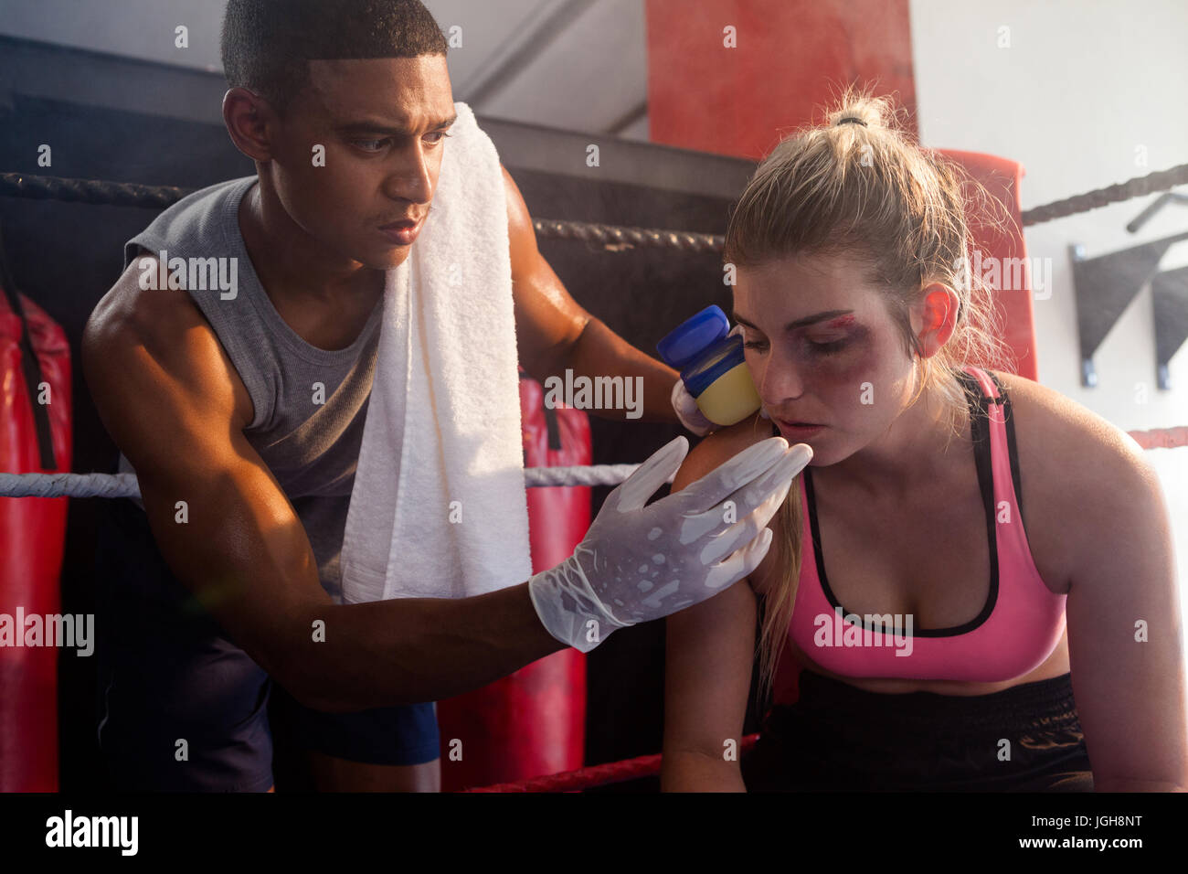 Trainer applying cream on woman face in boxing ring Stock Photo - Alamy