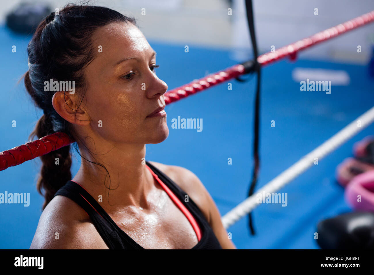 Thoughtful female boxer leaning on boxing ring rope Stock Photo - Alamy
