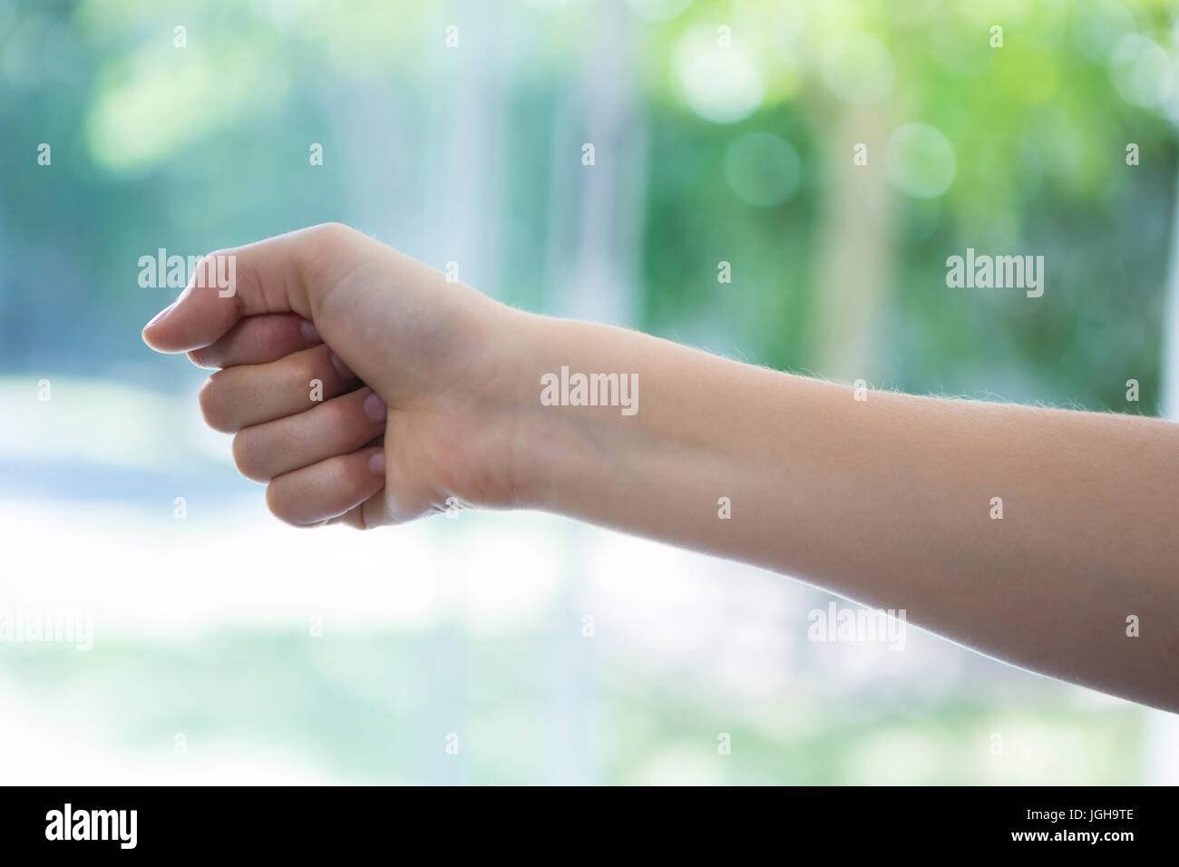 Cropped image of hand clenching fist against window Stock Photo - Alamy