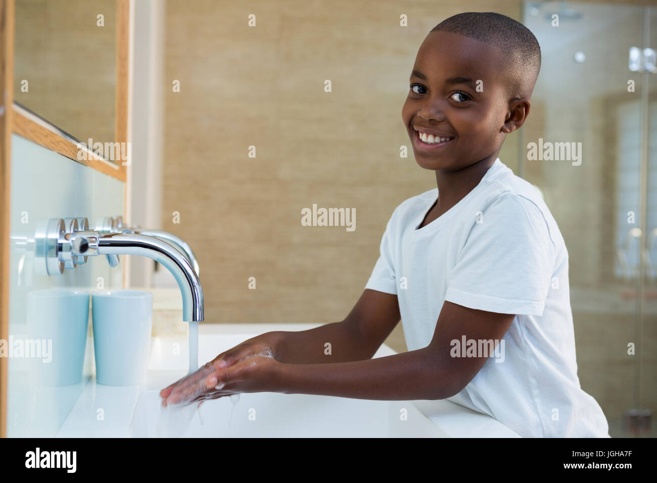 Portrait of smiling boy washing hands in sink at bathroom Stock Photo ...