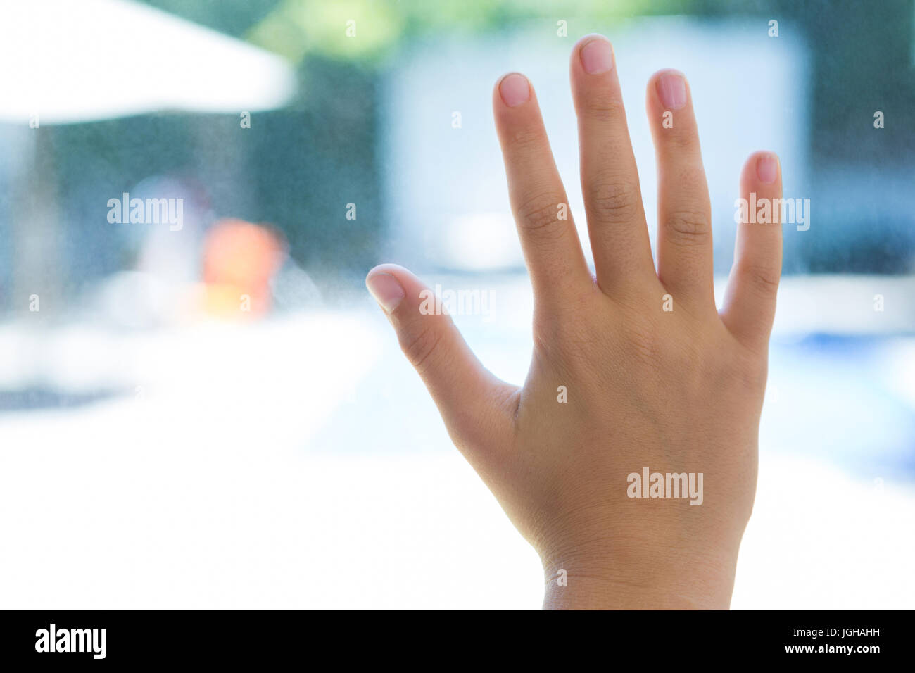 Close up of hand touching glass of window at home Stock Photo - Alamy