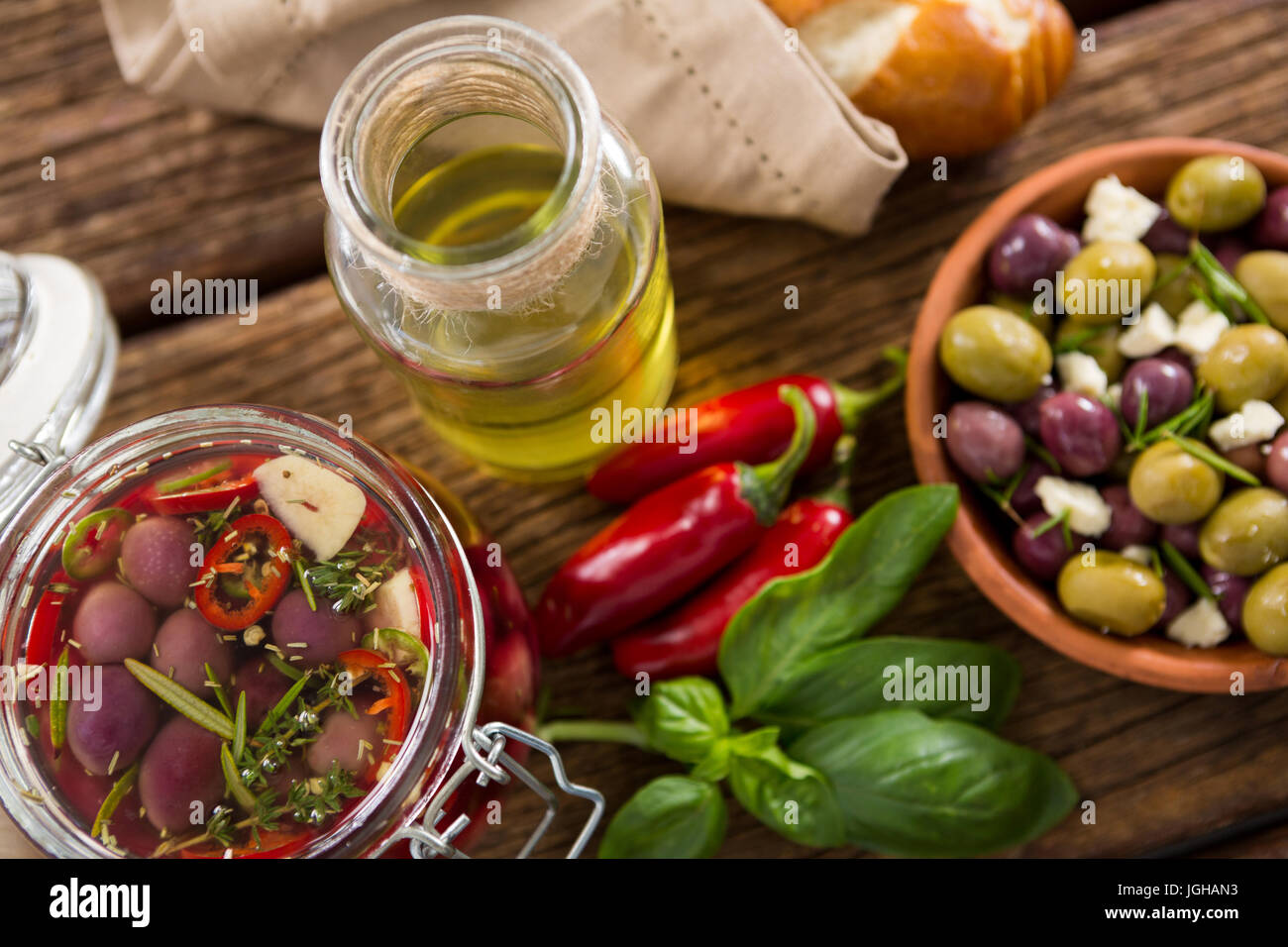 Pickled olives with ingredients on wooden table Stock Photo - Alamy