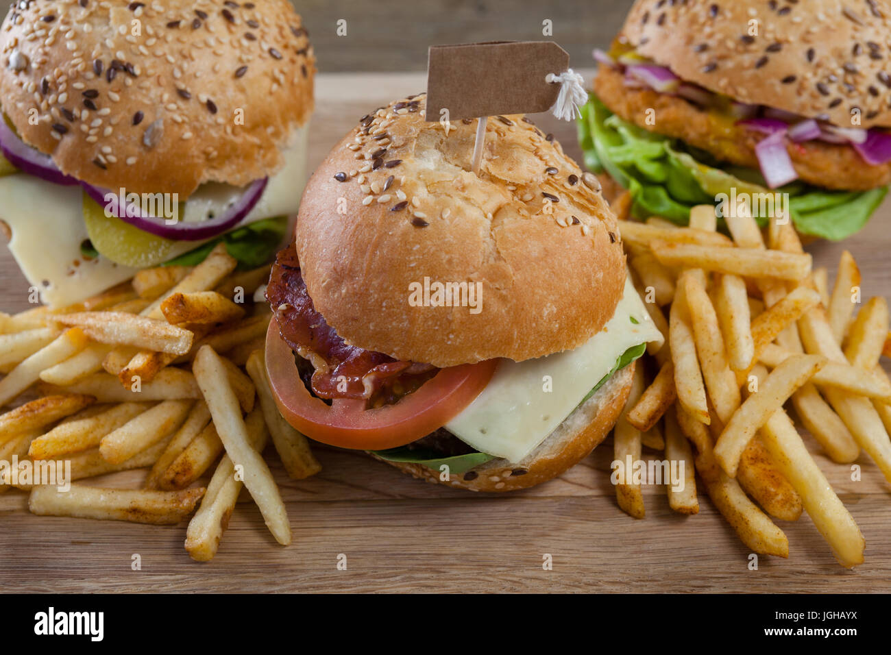 Close-up of various hamburger with tag and french fries on wooden table ...