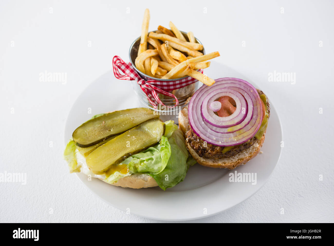 High angle view of open burger by French fries in container on plate ...