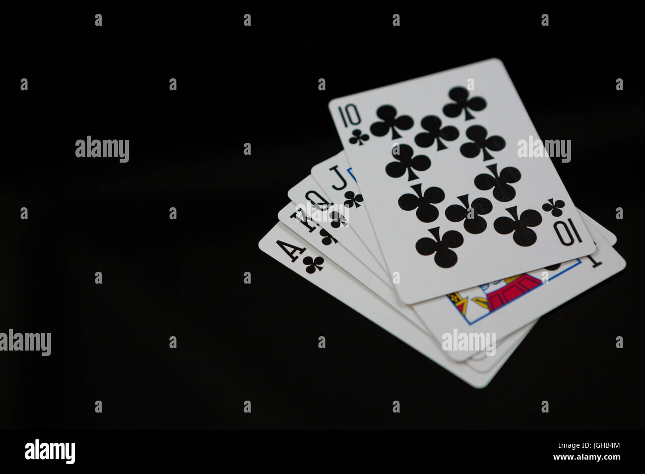 Close-up of clubs cards on black background Stock Photo - Alamy