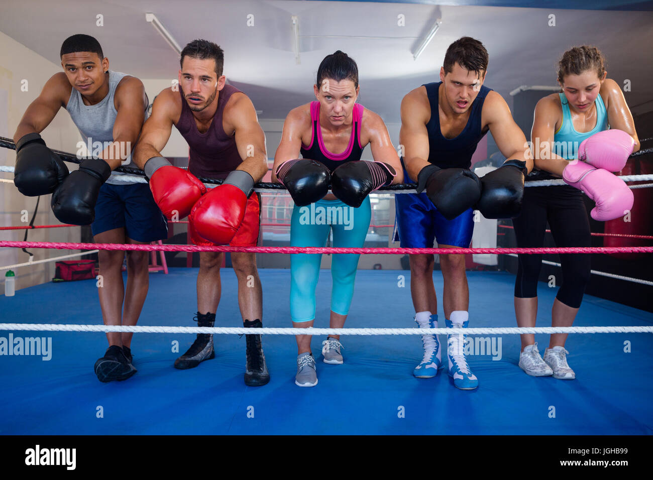 Exhausted young boxers leaning on rope in boxing ring Stock Photo - Alamy