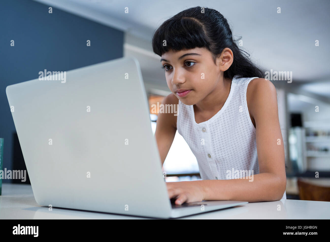 Girl using laptop in kitchen at home Stock Photo - Alamy