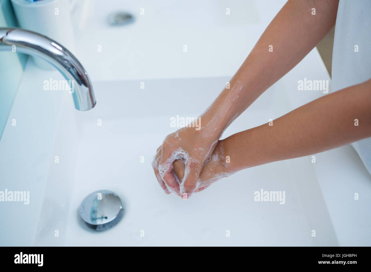High angle view of girl washing hands while standing by sink in ...