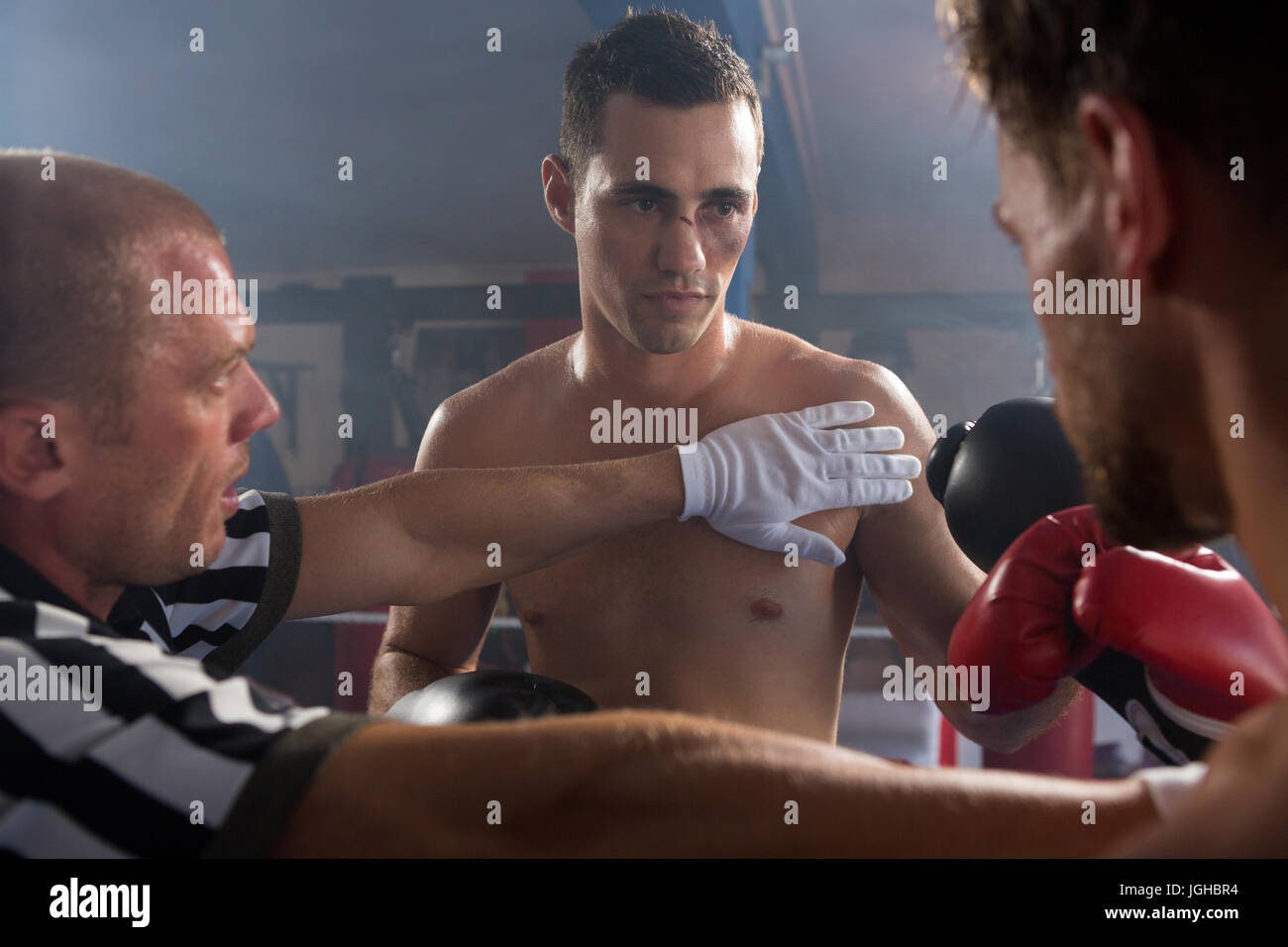 Referee stopping aggressive young male boxers in boxing ring Stock ...