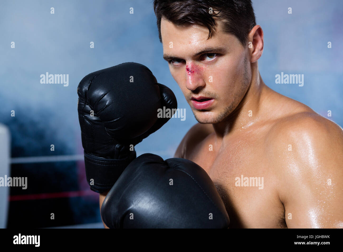 Close-up portrait of male boxer with bleeding nose at fitness studio ...