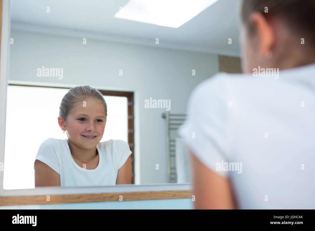 Girl standing while reflecting in mirror Stock Photo - Alamy