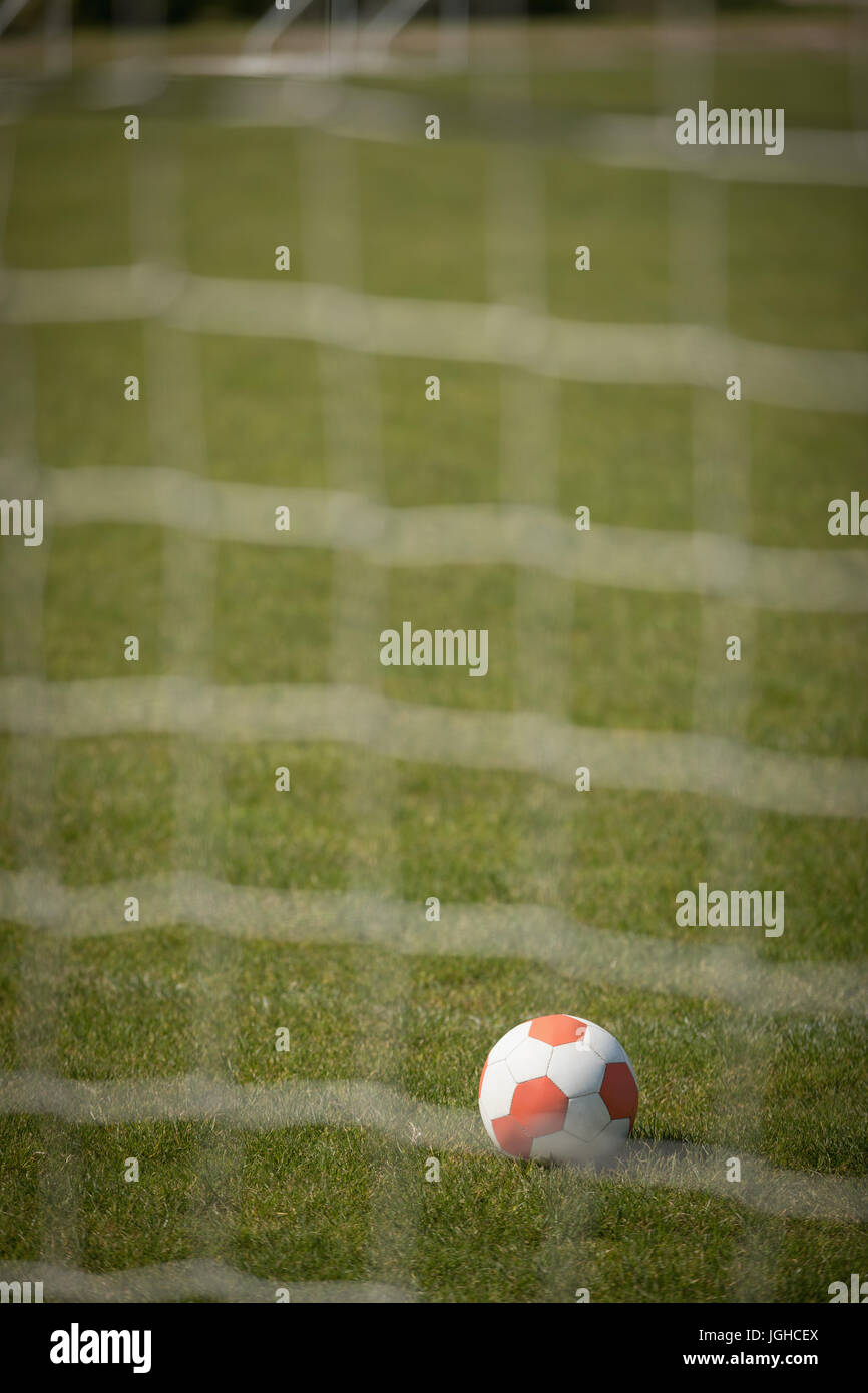 Soccer ball on playing field seen through net Stock Photo - Alamy