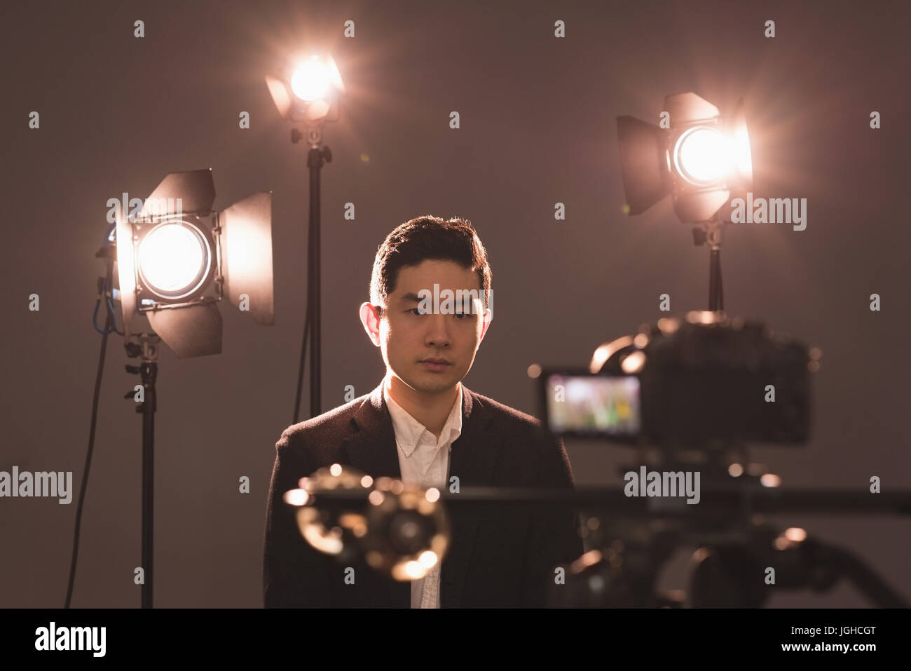 Video camera photographing male model sitting in studio Stock Photo - Alamy
