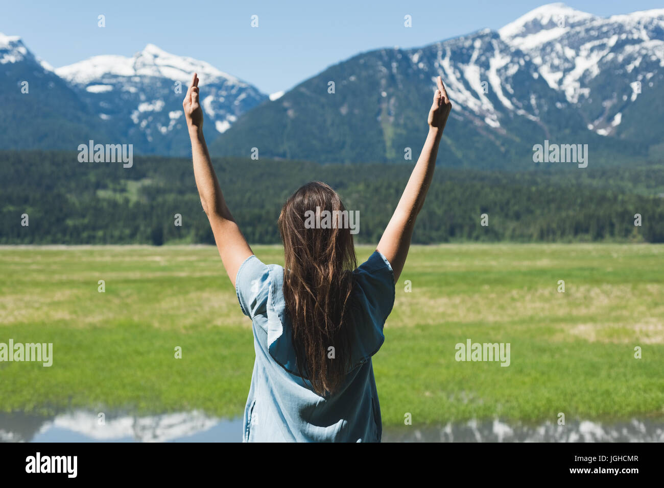 Rear view of woman with arms up looking at beautiful mountain Stock ...