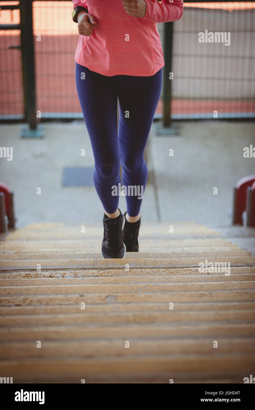Low section of female athlete moving up on steps at track and field ...