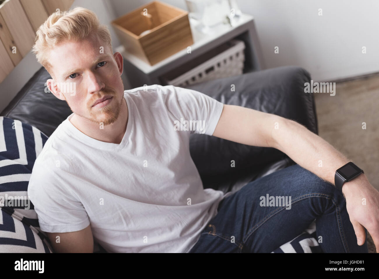Portrait of man sitting on sofa at home Stock Photo - Alamy