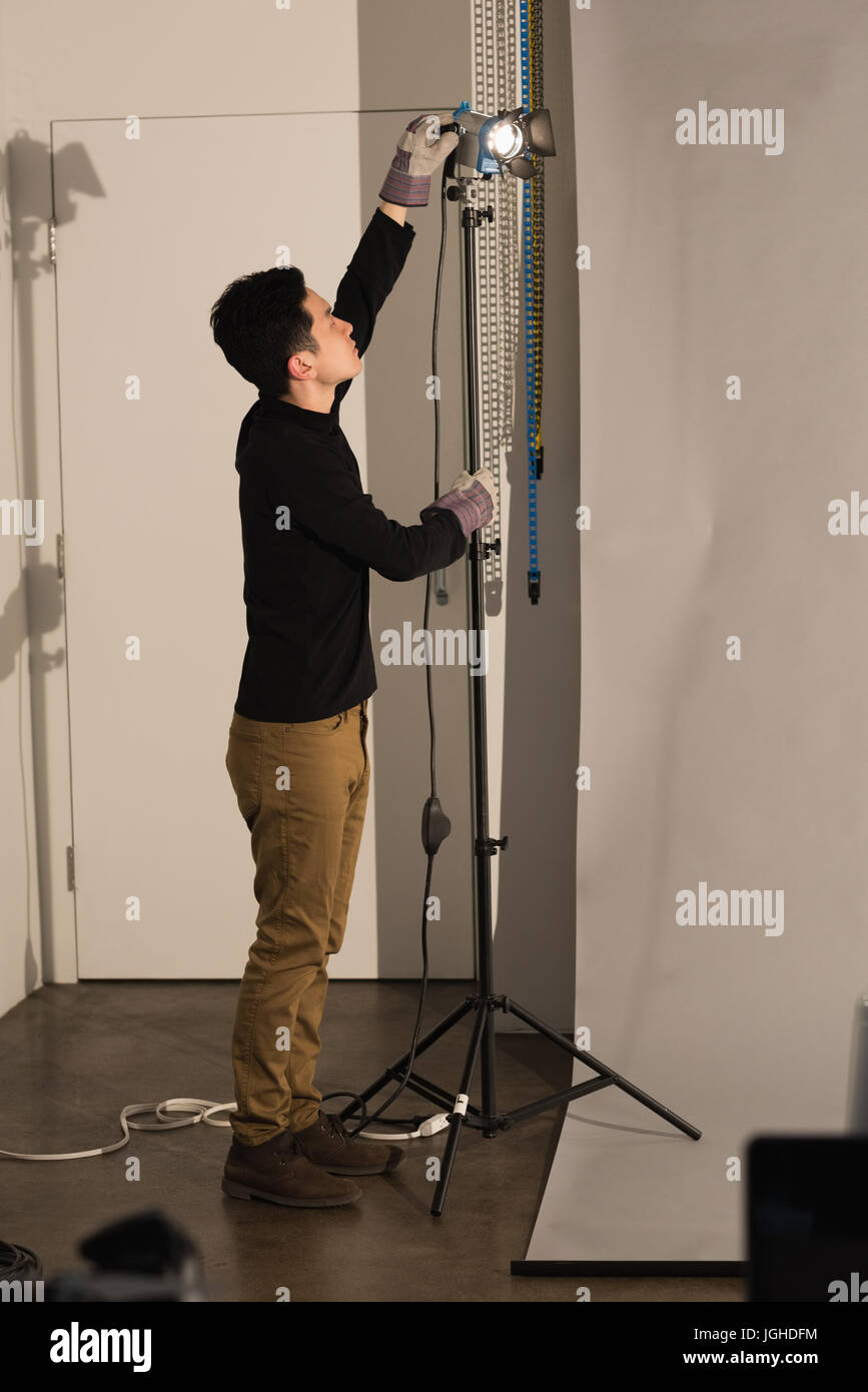 Full lengt of male photographer adjusting light at studio Stock Photo ...